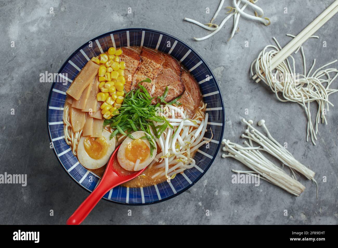 Asian noodle ramen with pork, marinated egg, sprout on grey clay ...