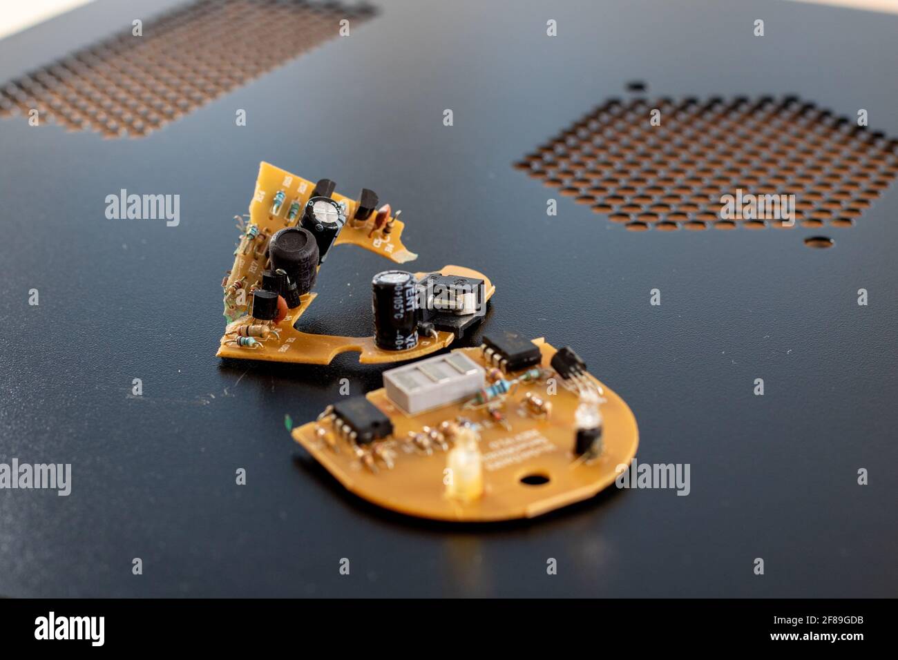 Broken circuit board on a perforated metal service looking a little ...