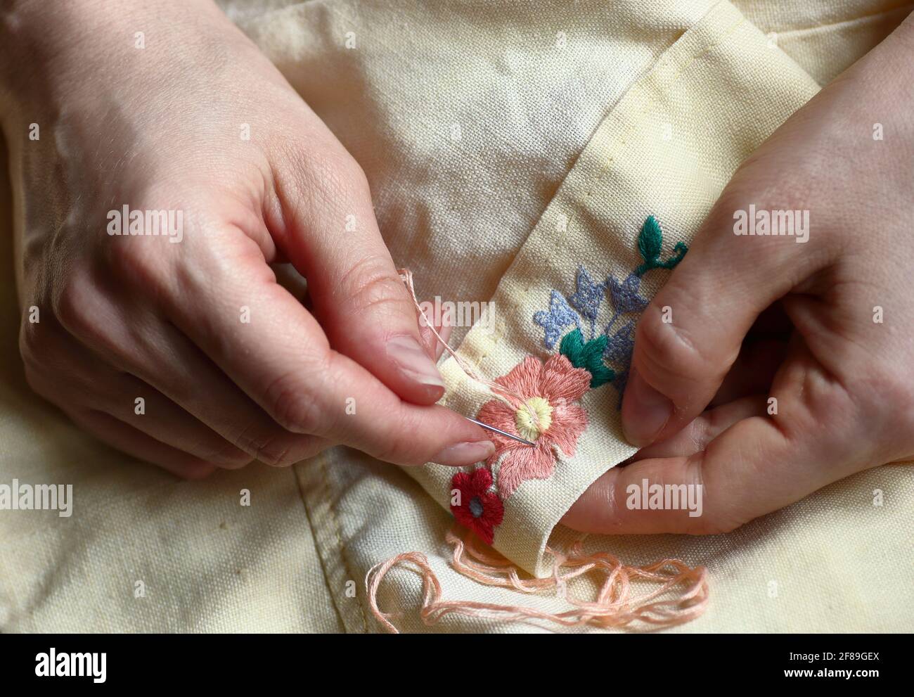 Embroidery in woman hands, female doing flower pattern embroidery on ...
