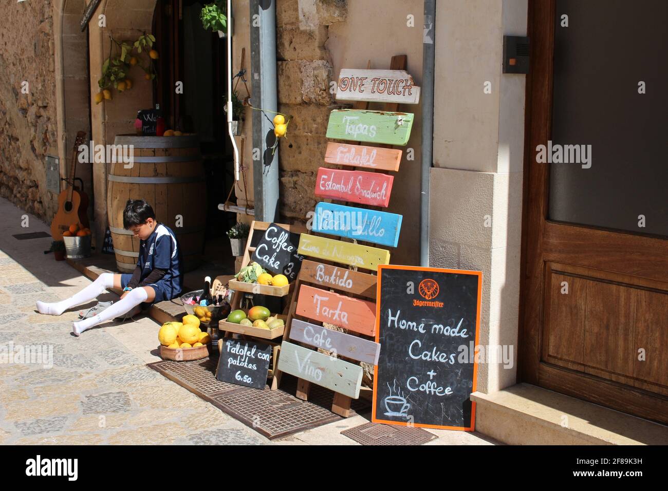 Boy in football kit sat on shop step Stock Photo - Alamy