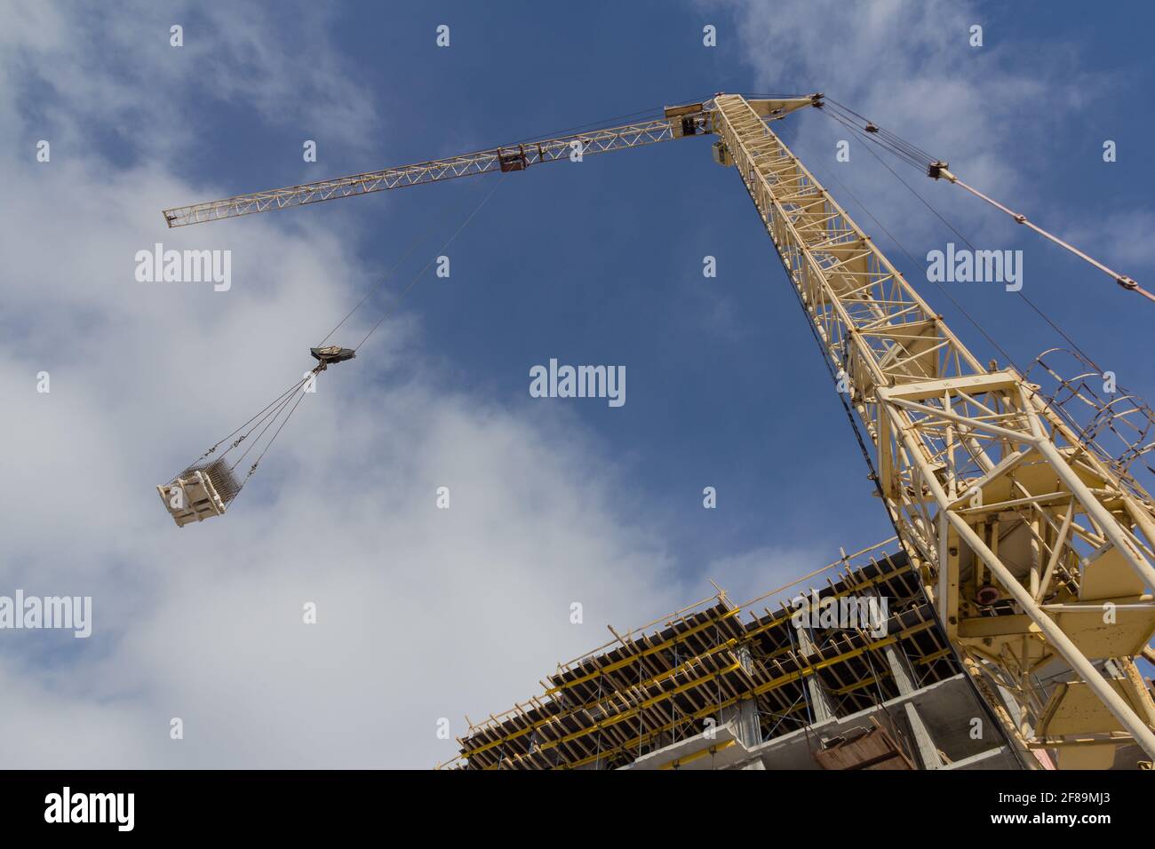 Tower crane on the background of the facade of the building. Lifting ...
