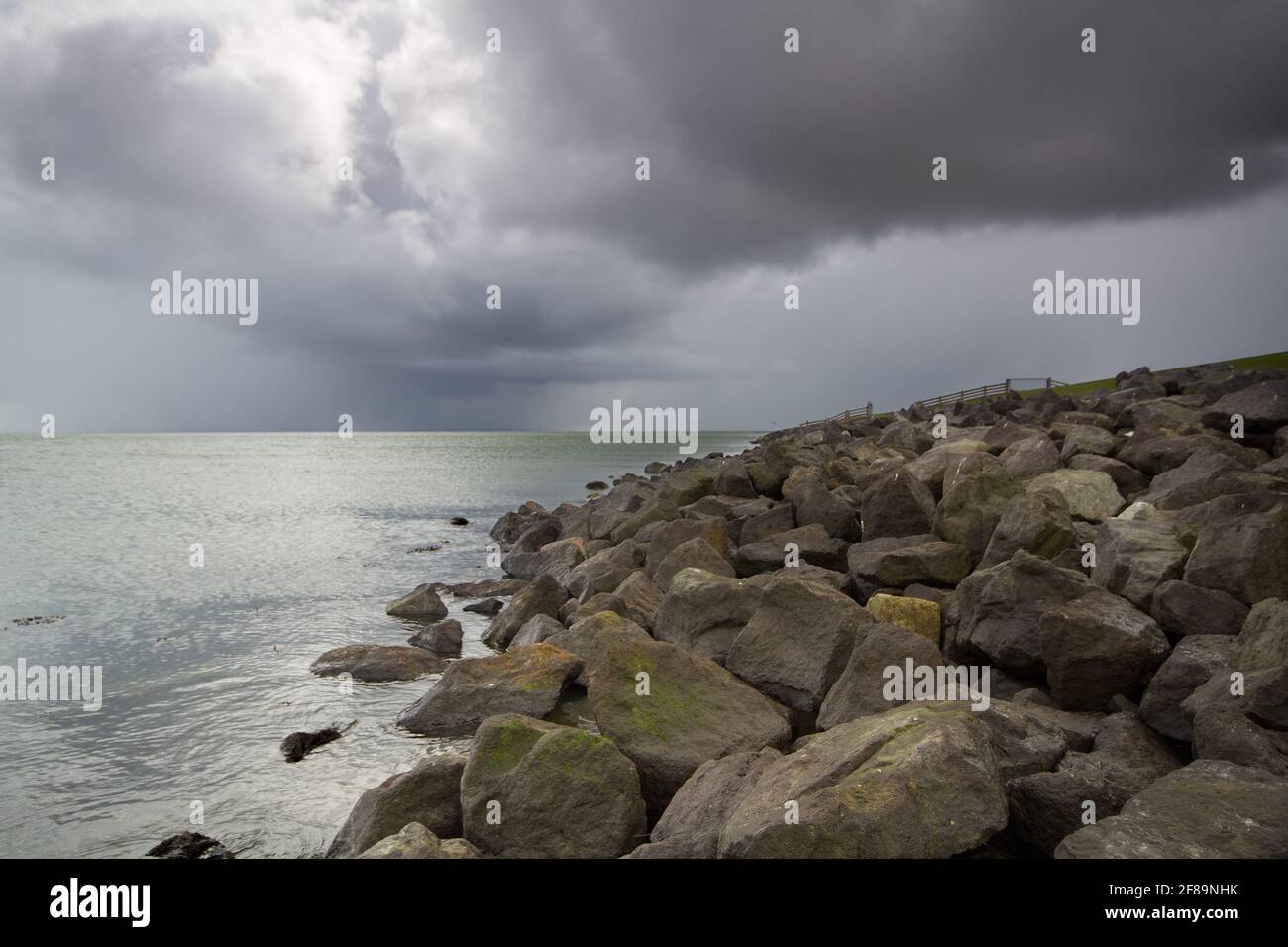 Toe protection of a solid sea dike, made of heavy boulders, under dark ...