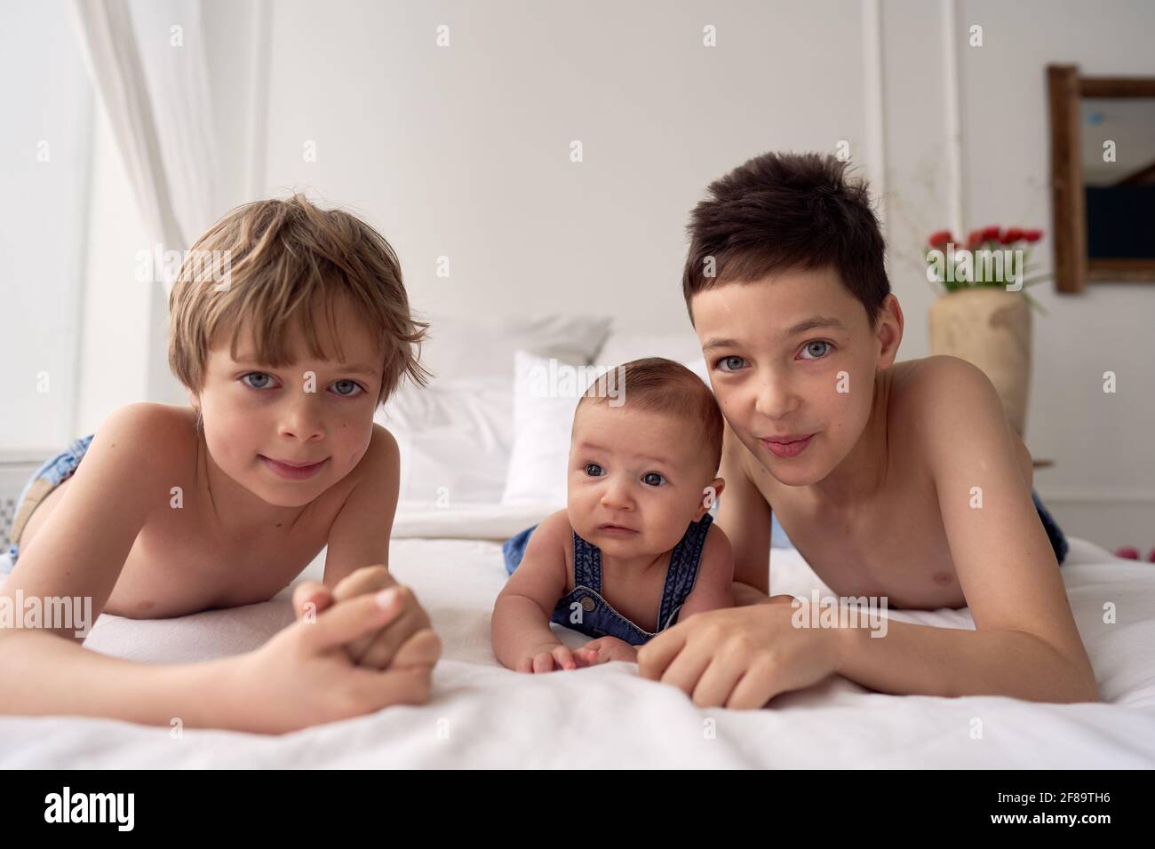 Three funny brothers boys are lying on the bed and having fun Stock ...