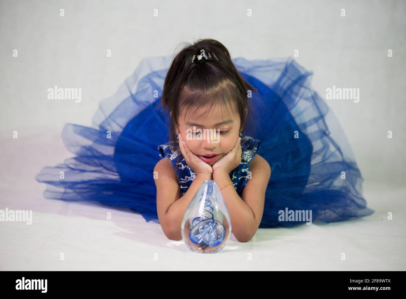 Beautiful shot of an adorable Southeast Asian baby girl wearing a blue ...