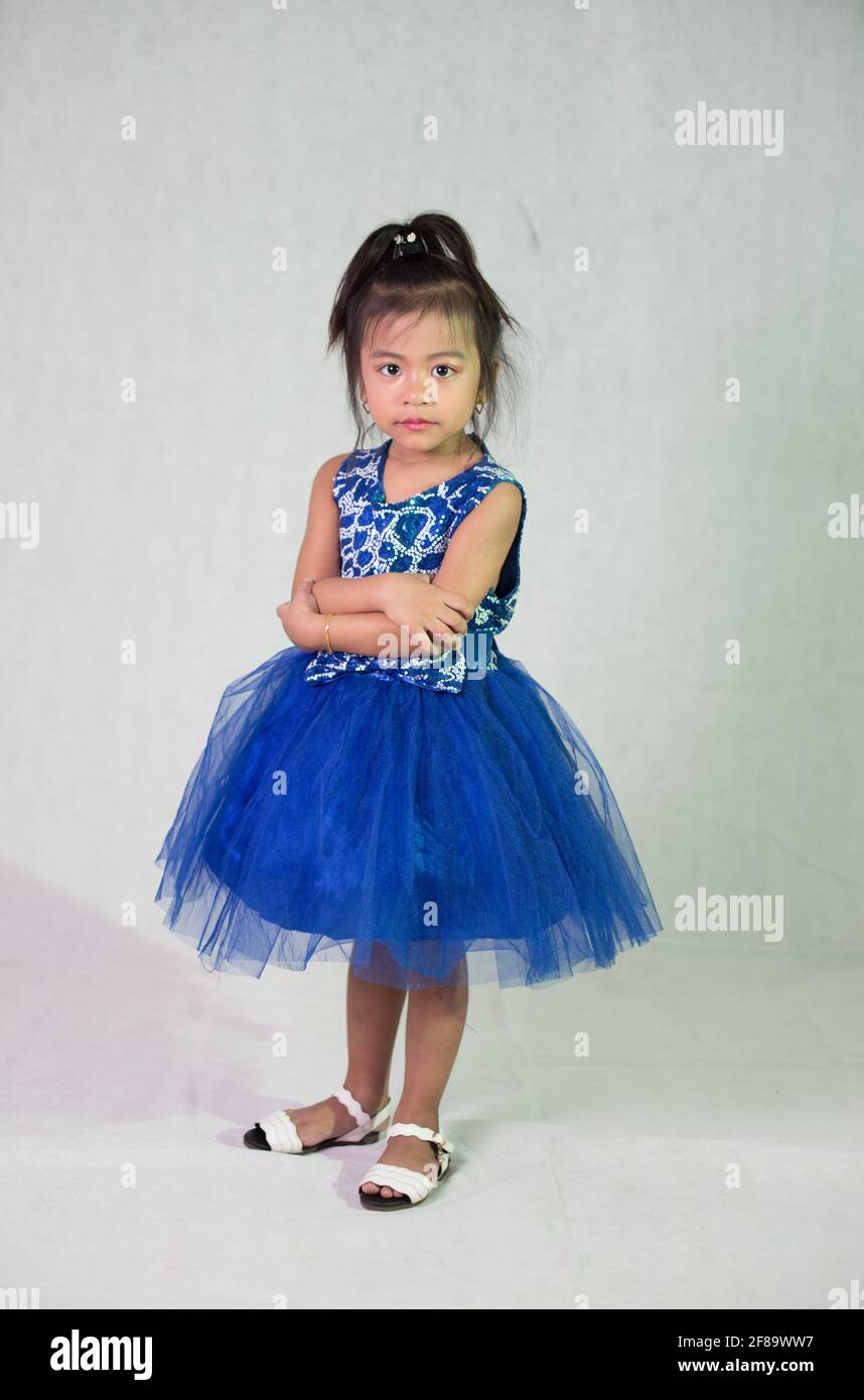 Vertical shot of an adorable Southeast Asian baby girl wearing a blue ...
