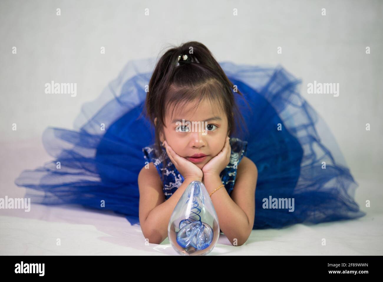 Beautiful shot of an adorable Southeast Asian baby girl wearing a blue ...