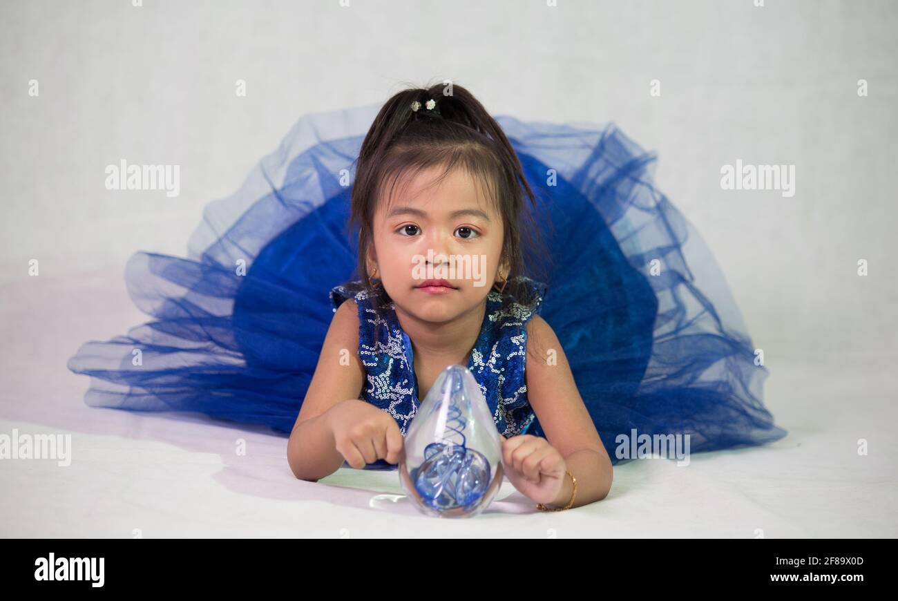 Beautiful shot of an adorable Southeast Asian baby girl wearing a blue ...