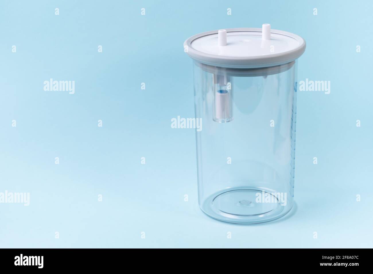 Plastic canister from medical suction machine on blue backdrop Stock ...
