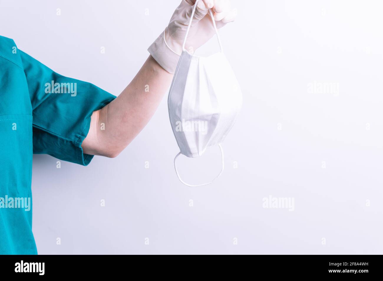 Surgeon holding a white face mask from the operating room concept ...