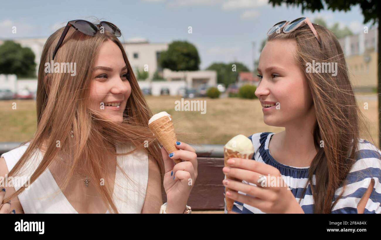 Two girls friends eating ice cream on the street of the city Stock ...