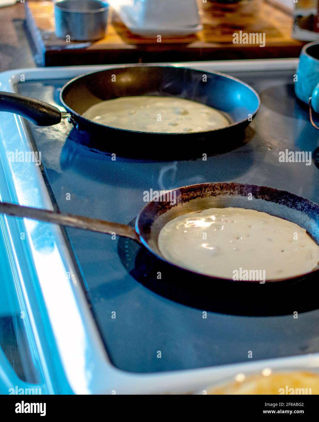 making crepes with two pans on a stove top Stock Photo - Alamy