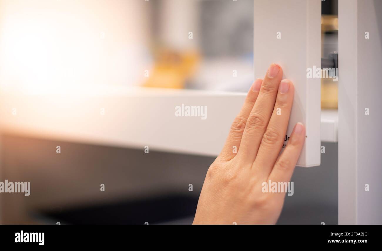 Close up female hand pushing on the position for open white wood ...