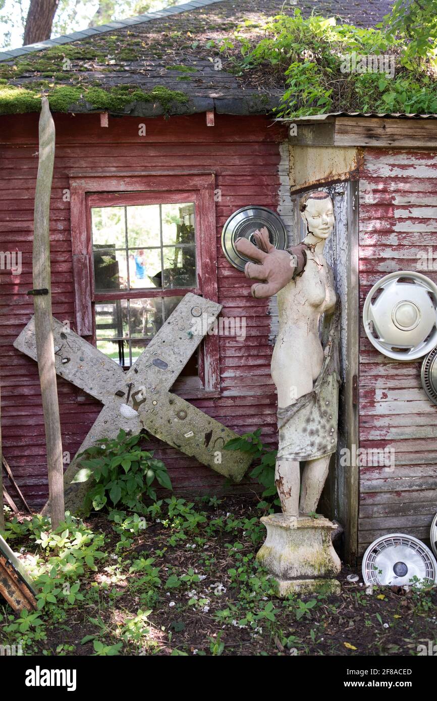 A worn out statue reaches out from the corner of a rustic barn, a ...
