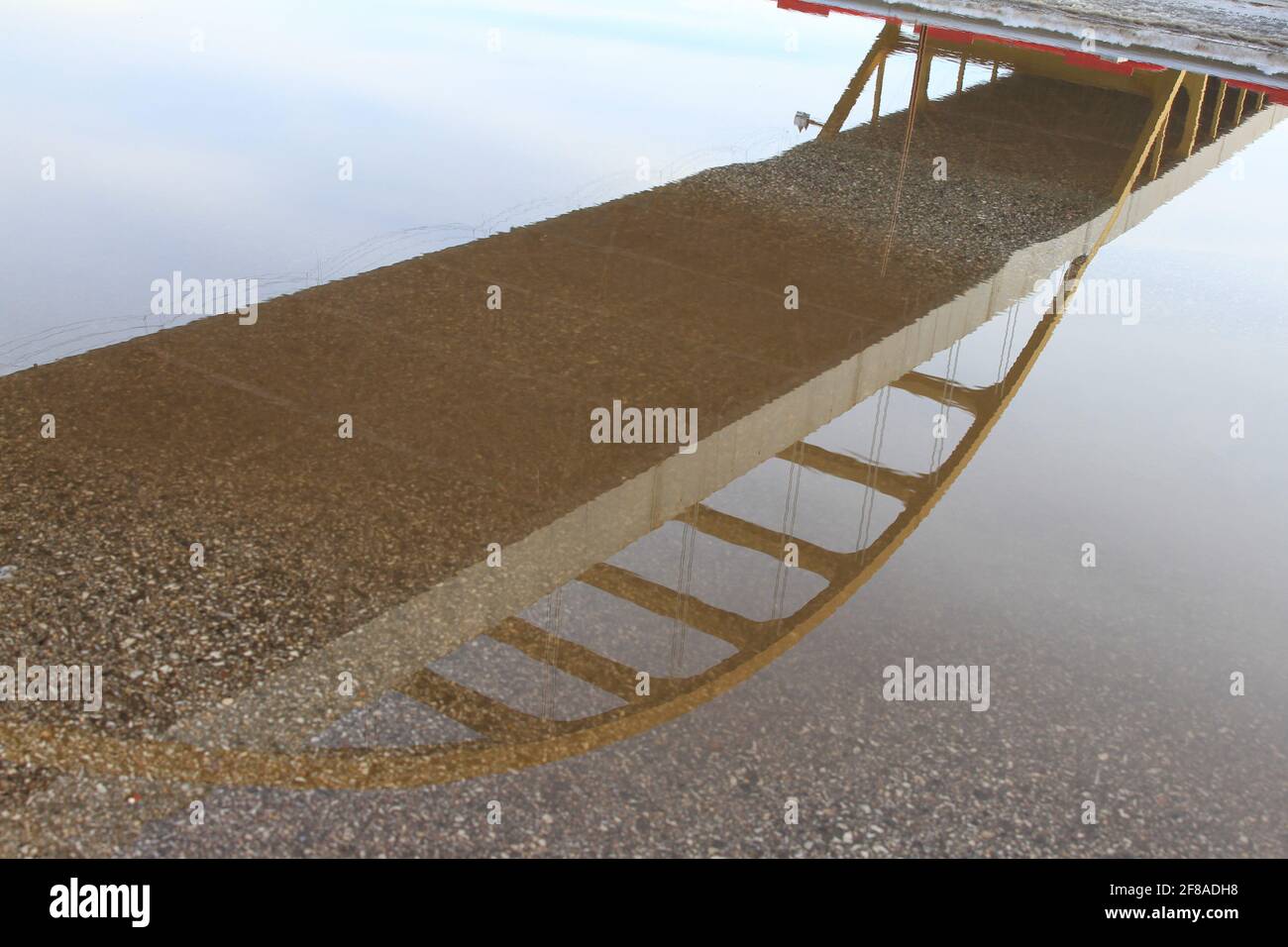 Reflection of Hone bridge in puddle on pavement in Milwaukee, Wisconsin ...