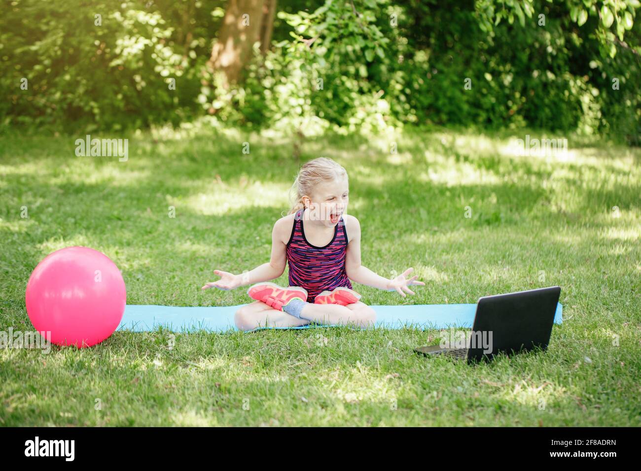 Angry mad girl child doing sport workout outdoors online. Video yoga ...