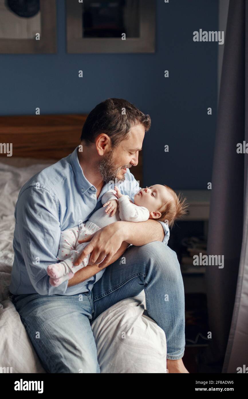 Fathers Day holiday. Middle age Caucasian father with sleeping newborn ...