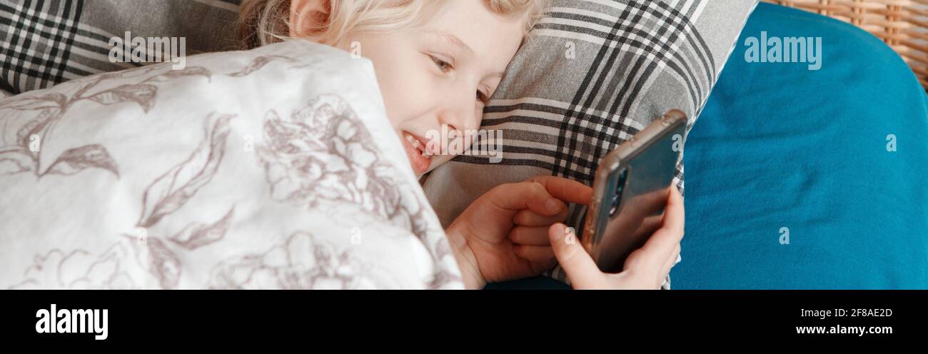 Girl lying in bed in morning and texting talking at social media on a ...