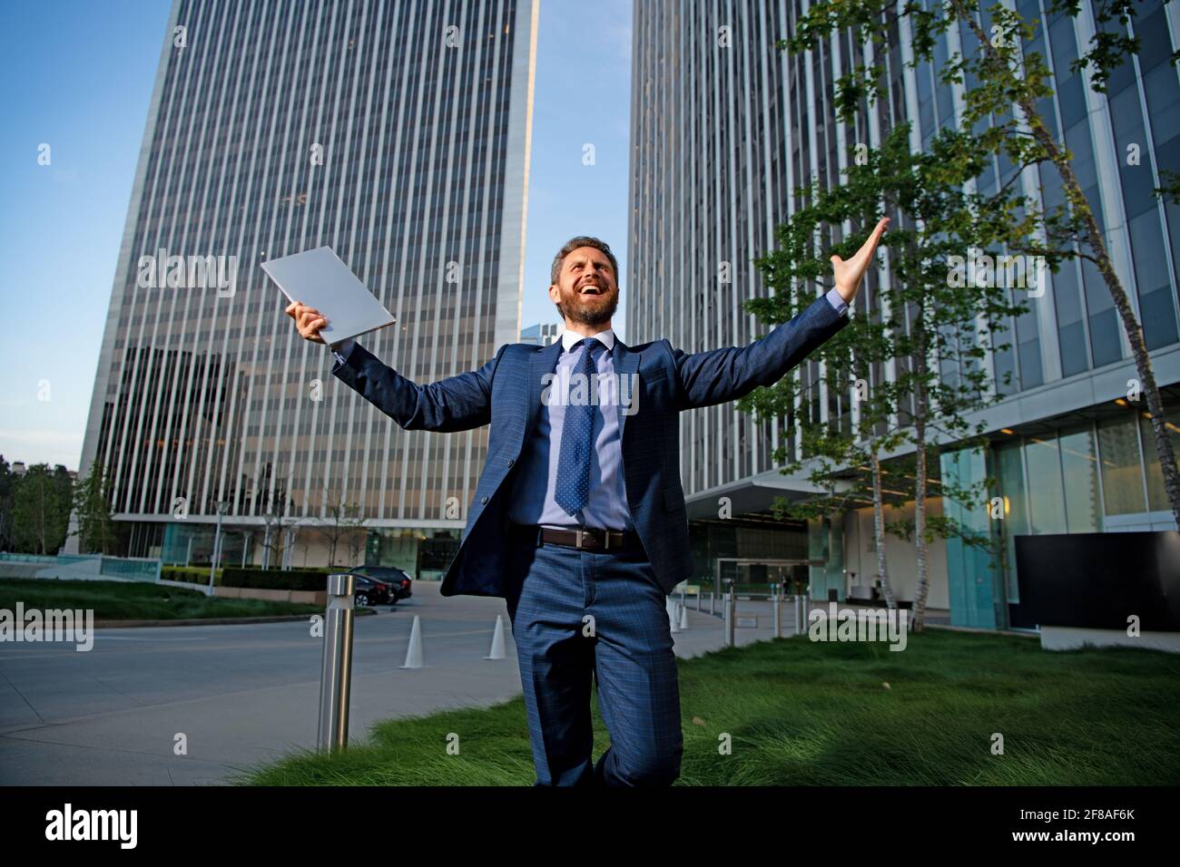 Welcome business. Happy leader standing in front of company building ...