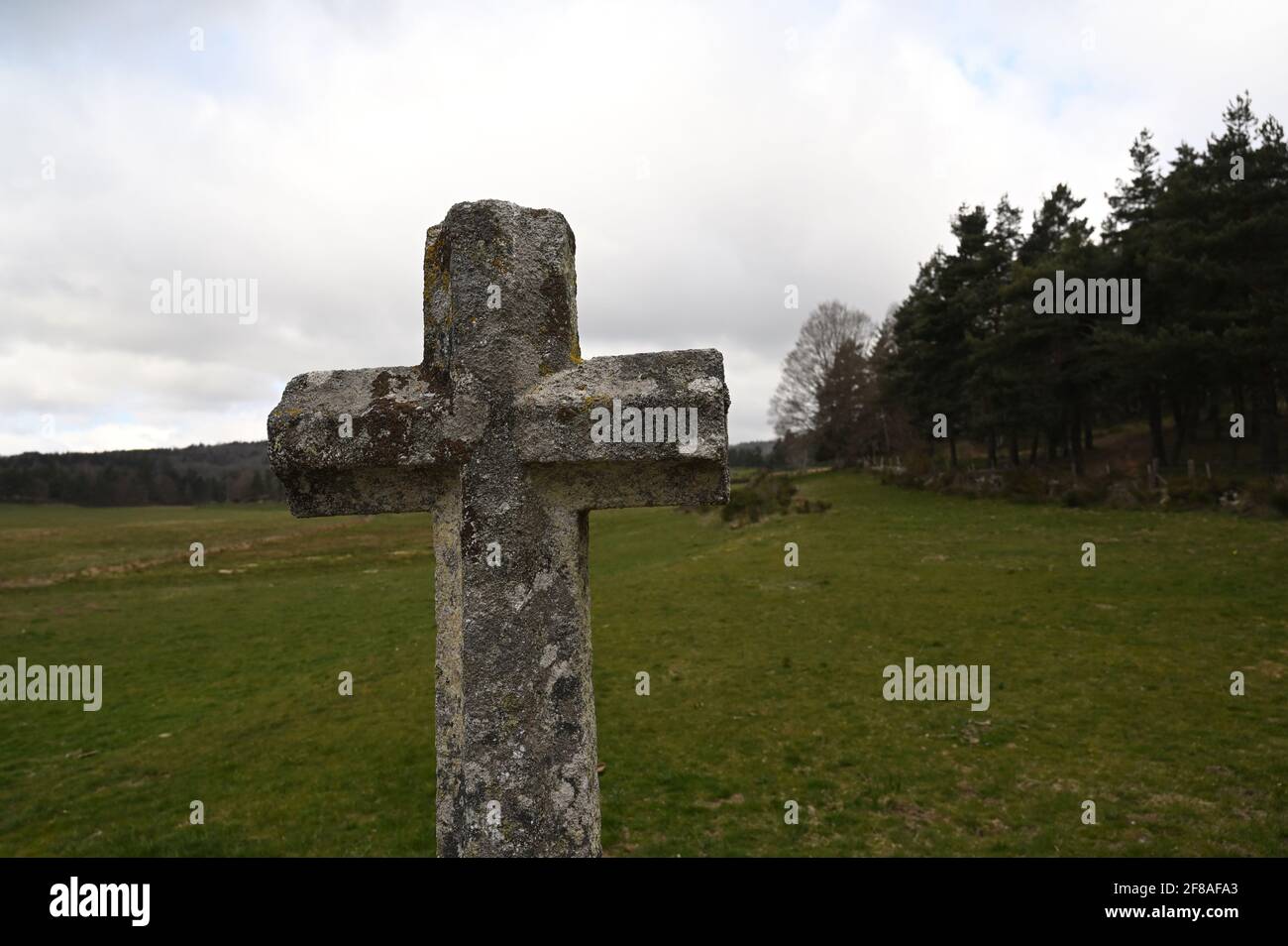 Granite stone christian cross in a green field Stock Photo - Alamy