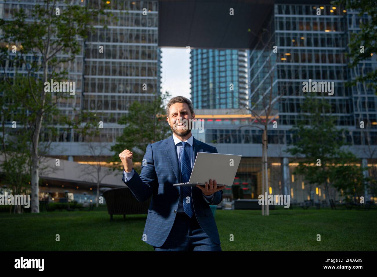 Excited business man. Business man standing in the the city is happy to ...