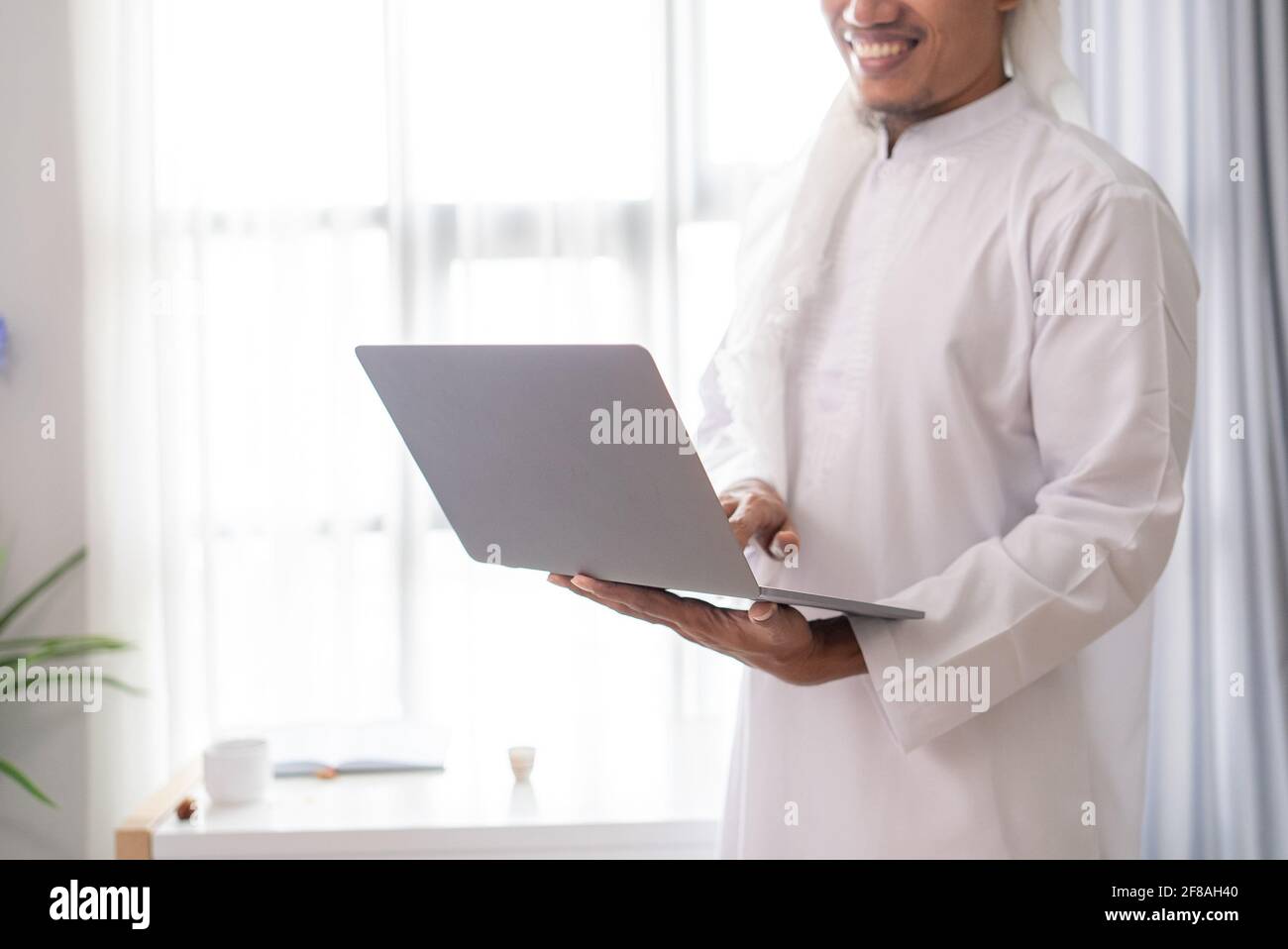 arabic muslim businessman standing portrait holding a laptop against ...