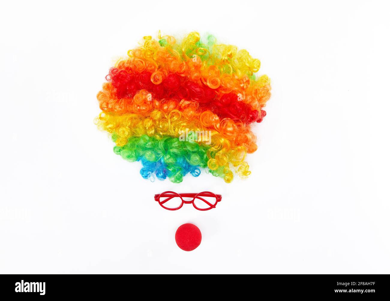Top view of funny clown face formed with a colorful wig, glasses, and ...