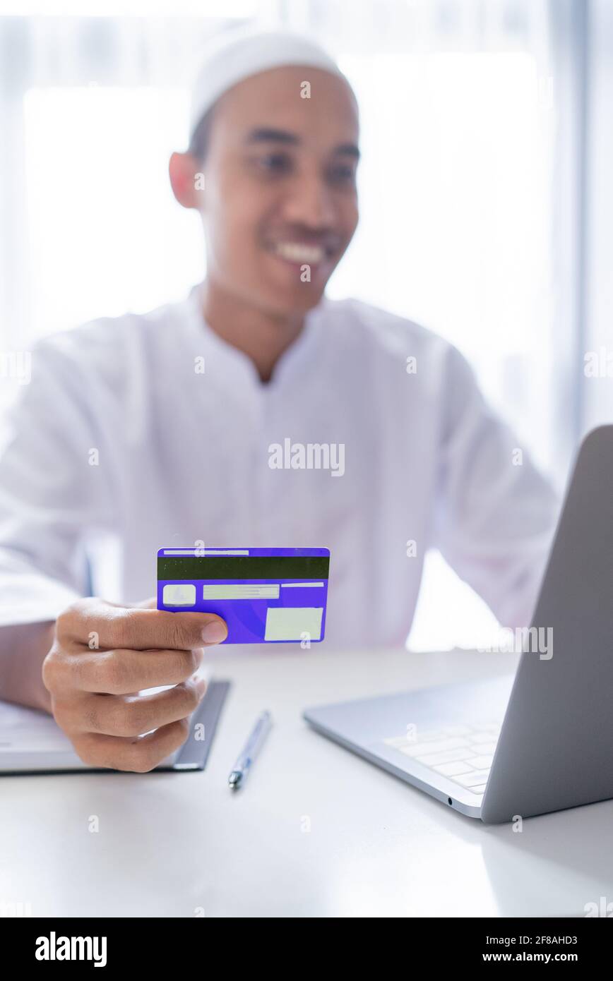 muslim asian man using credit card for online shop payment Stock Photo ...