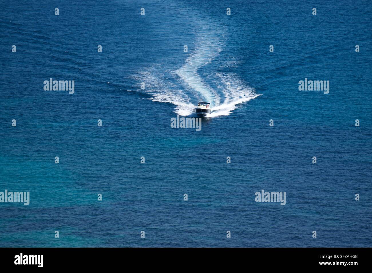 Boat quickly floating on the water surface and leaving a trail on the ...