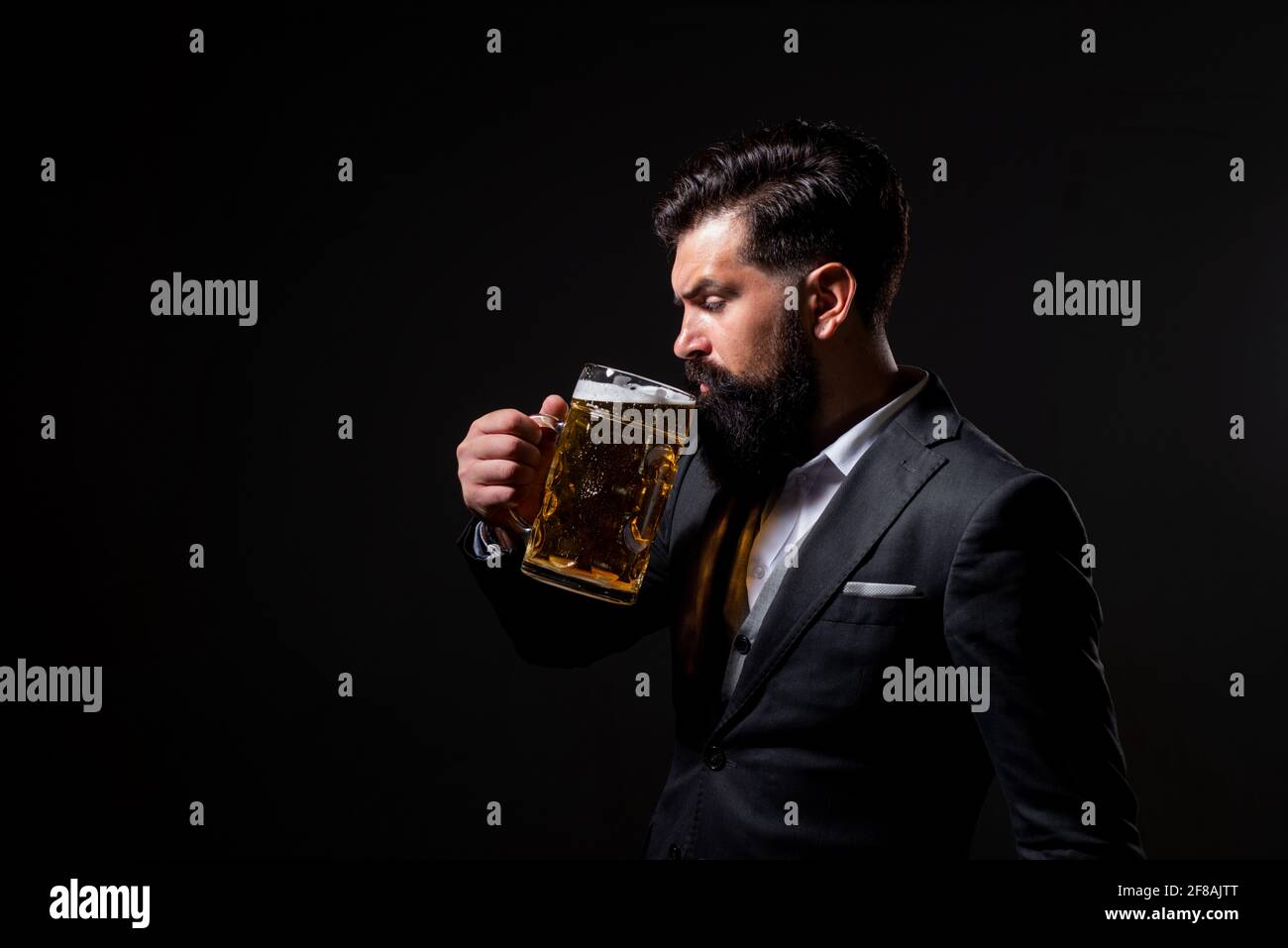 Happy elegant man drinking beer. Brewer holding glass with beer ...