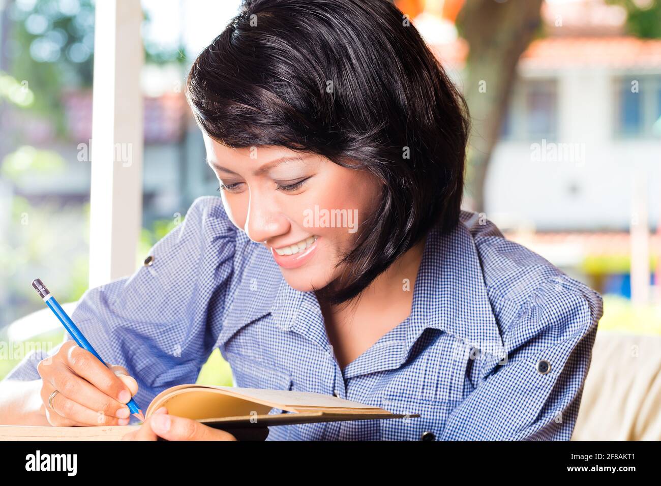 Student - young woman or girl sitting with books in a library learning ...