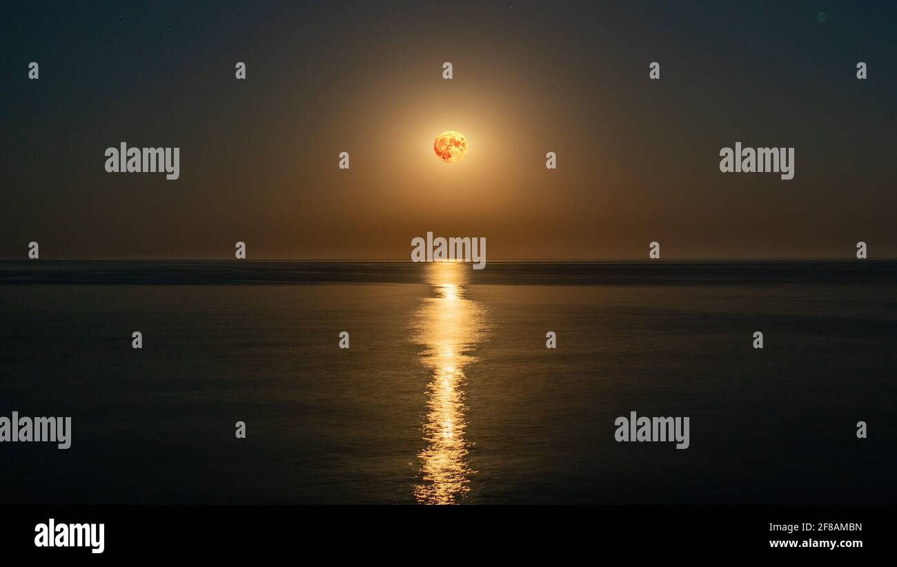 Super full blood moon and moon light over the sea. Full red moon with ...