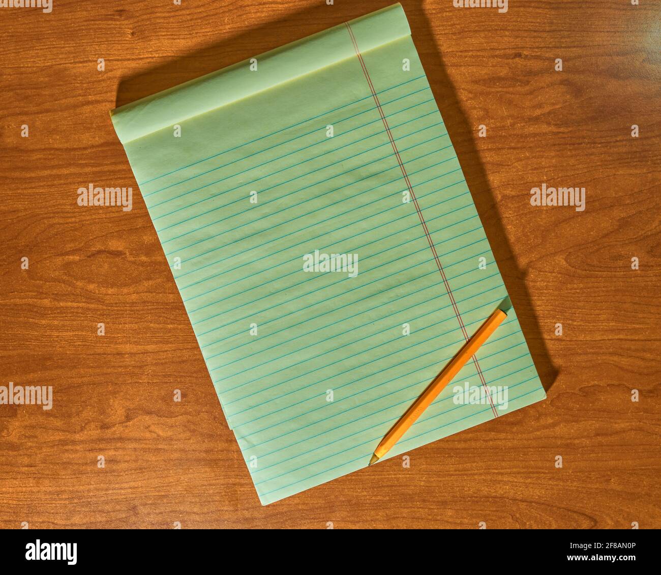 Top view of lined open sideways notebook with pencil on it, on wooden ...