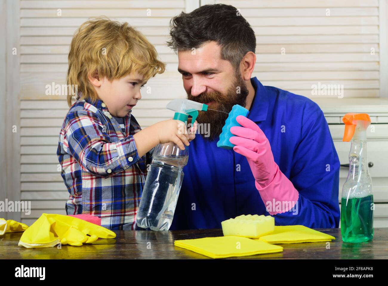 Dad and son with cleaning supplies. Father has fun with child and clean ...