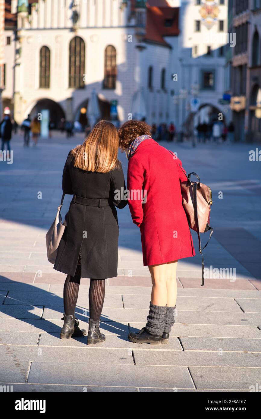 Vertical shot of two women from behind in Old Town Hall Munich Germany ...
