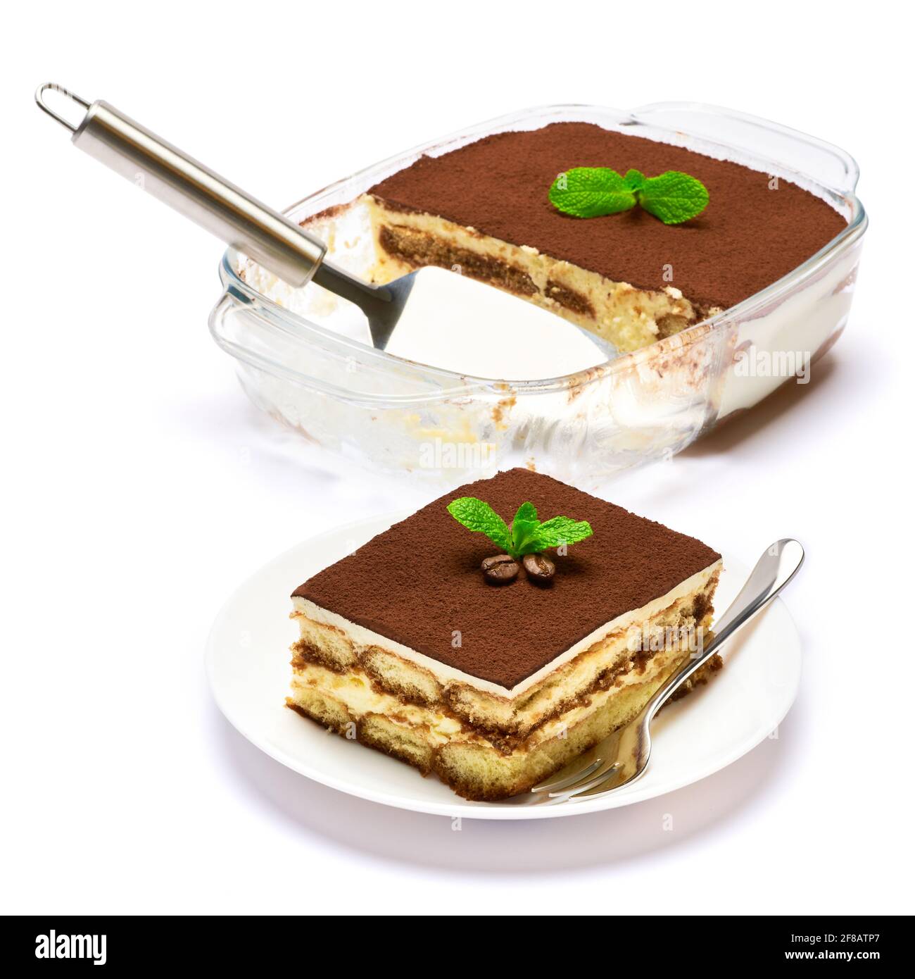 Traditional Italian Tiramisu dessert in glass baking dish, portion on ...