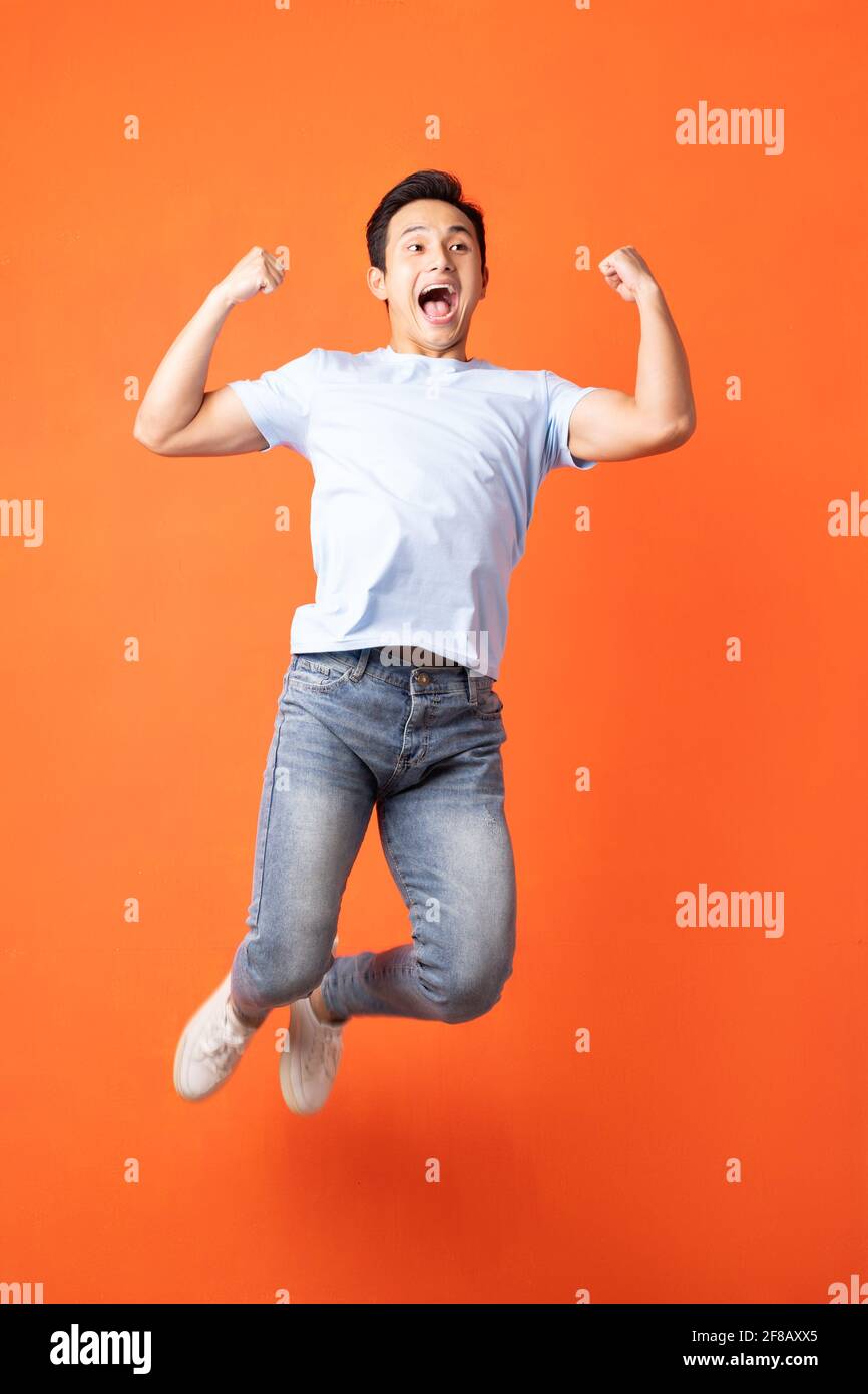 Asian man jumping and shouting Stock Photo - Alamy