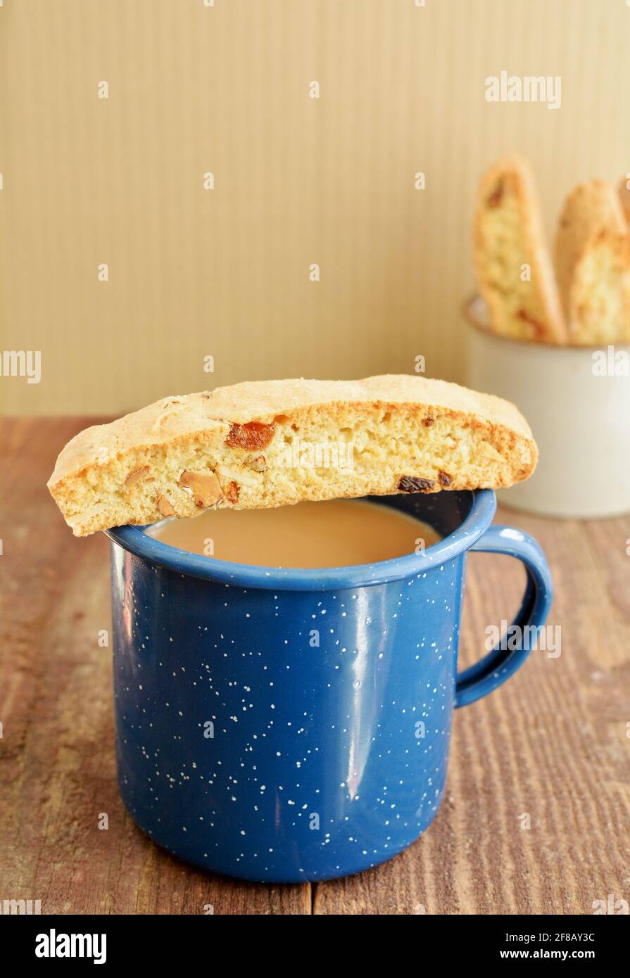 Apricot blueberry biscotti in rustic blue camp mug in vertical format ...
