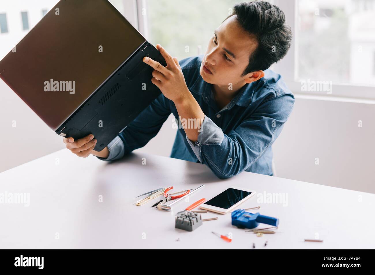 The Asian man was taking out a broken computer to repair it Stock Photo ...