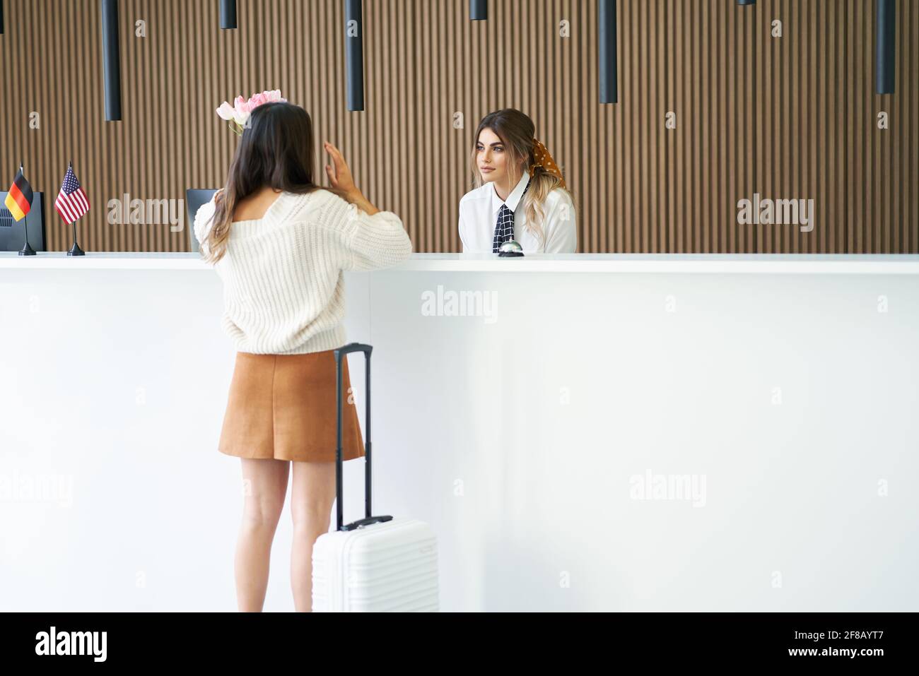 Female tourist waiting at reception desk in hotel Stock Photo - Alamy