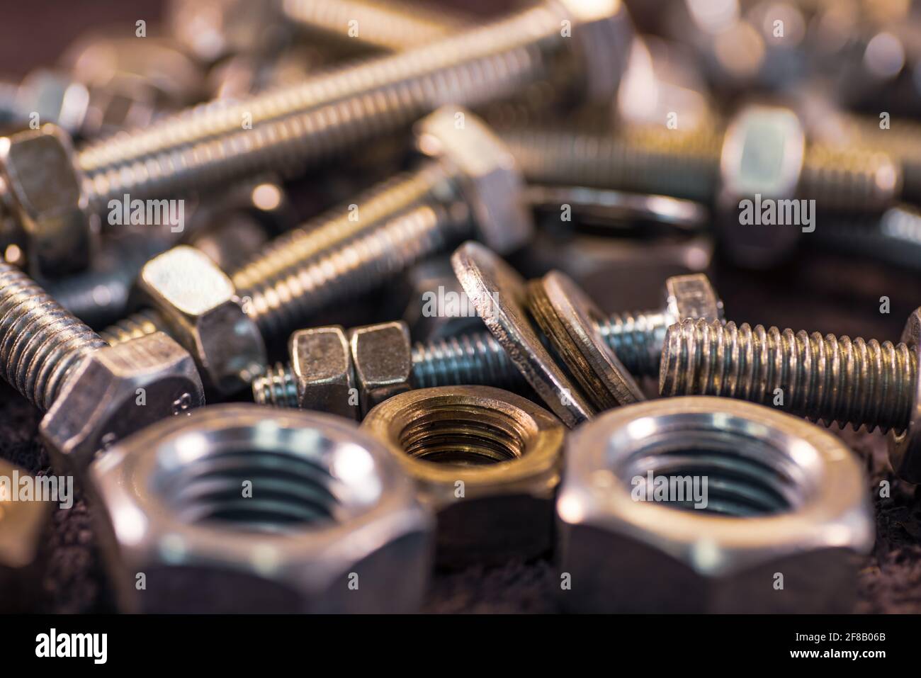 Metal chrome bolts and nuts in a chaotic order industrial background ...
