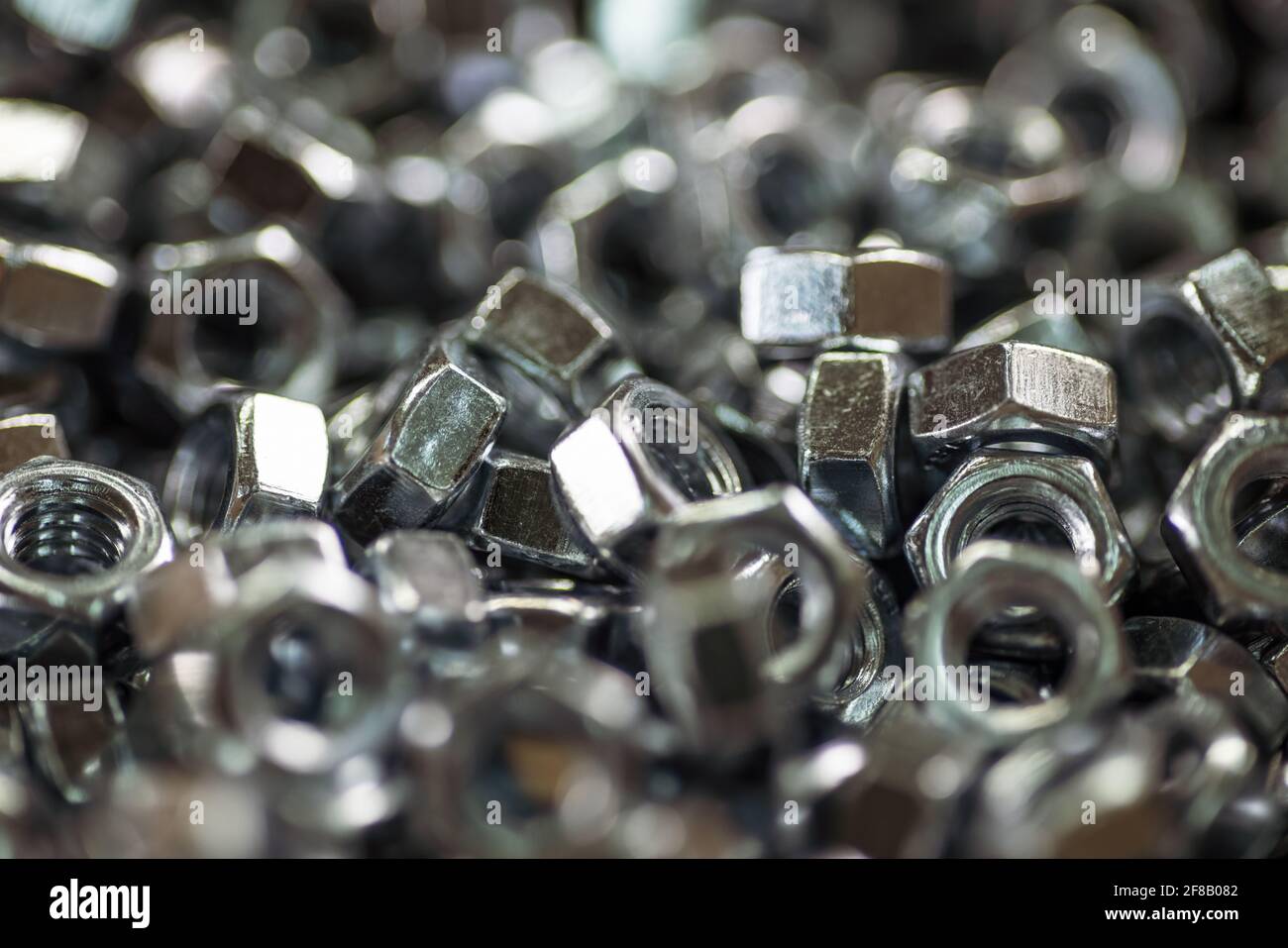 Metal chrome nuts in a chaotic order industrial background Stock Photo ...