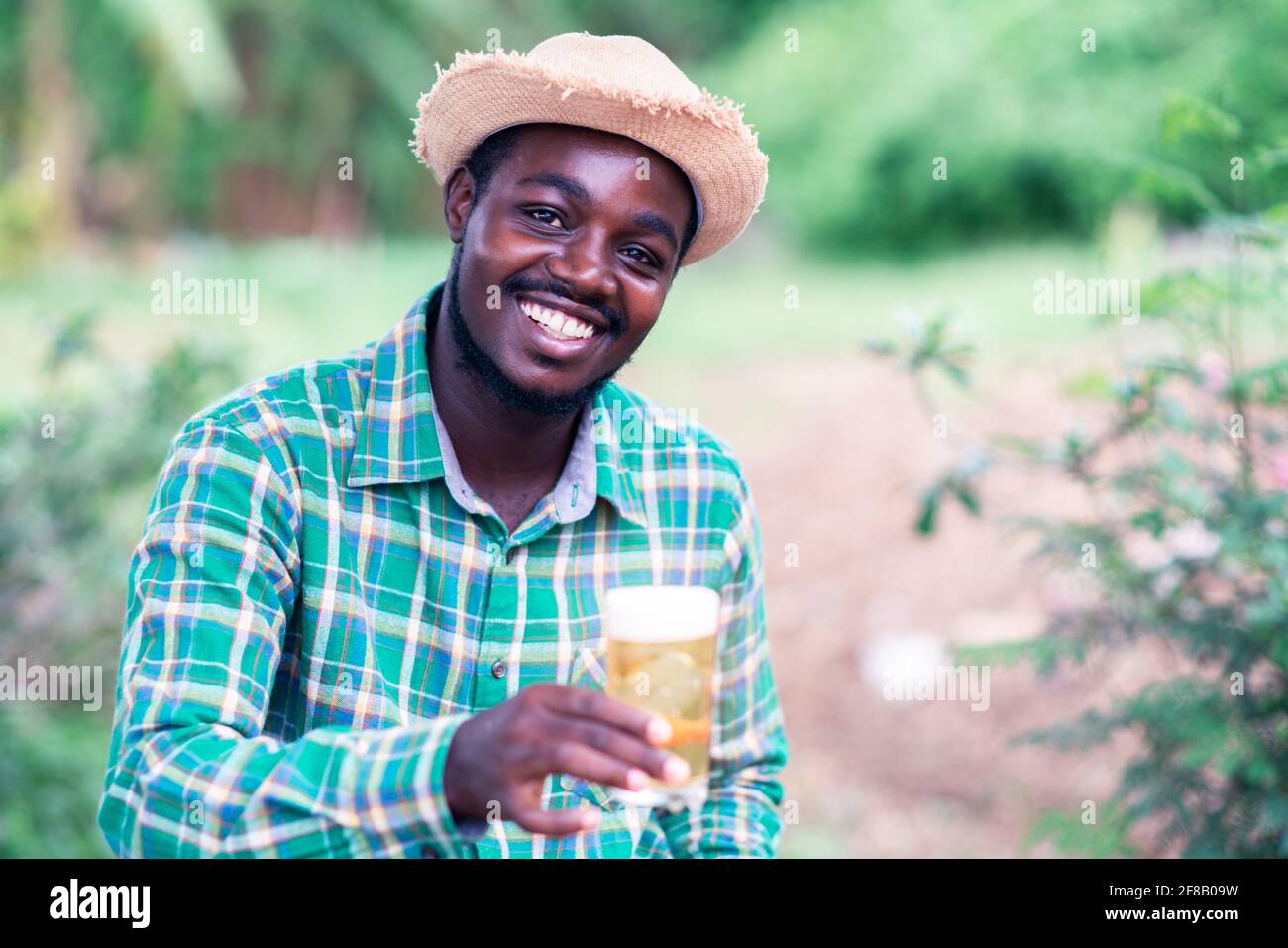 Happy African man drinking ice beer Stock Photo - Alamy