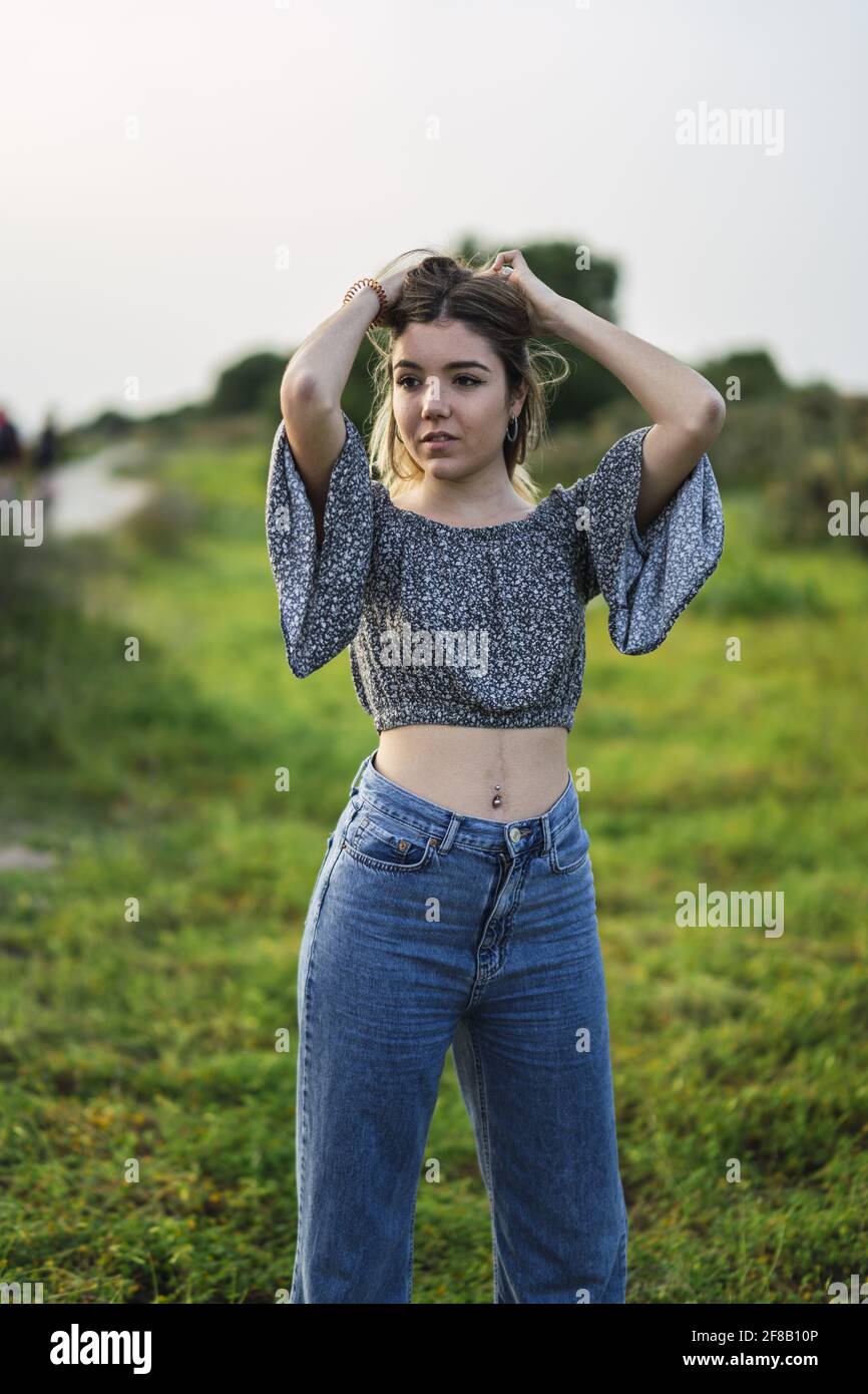 Shallow focus of a young woman wearing jeans with a floral crop top in ...