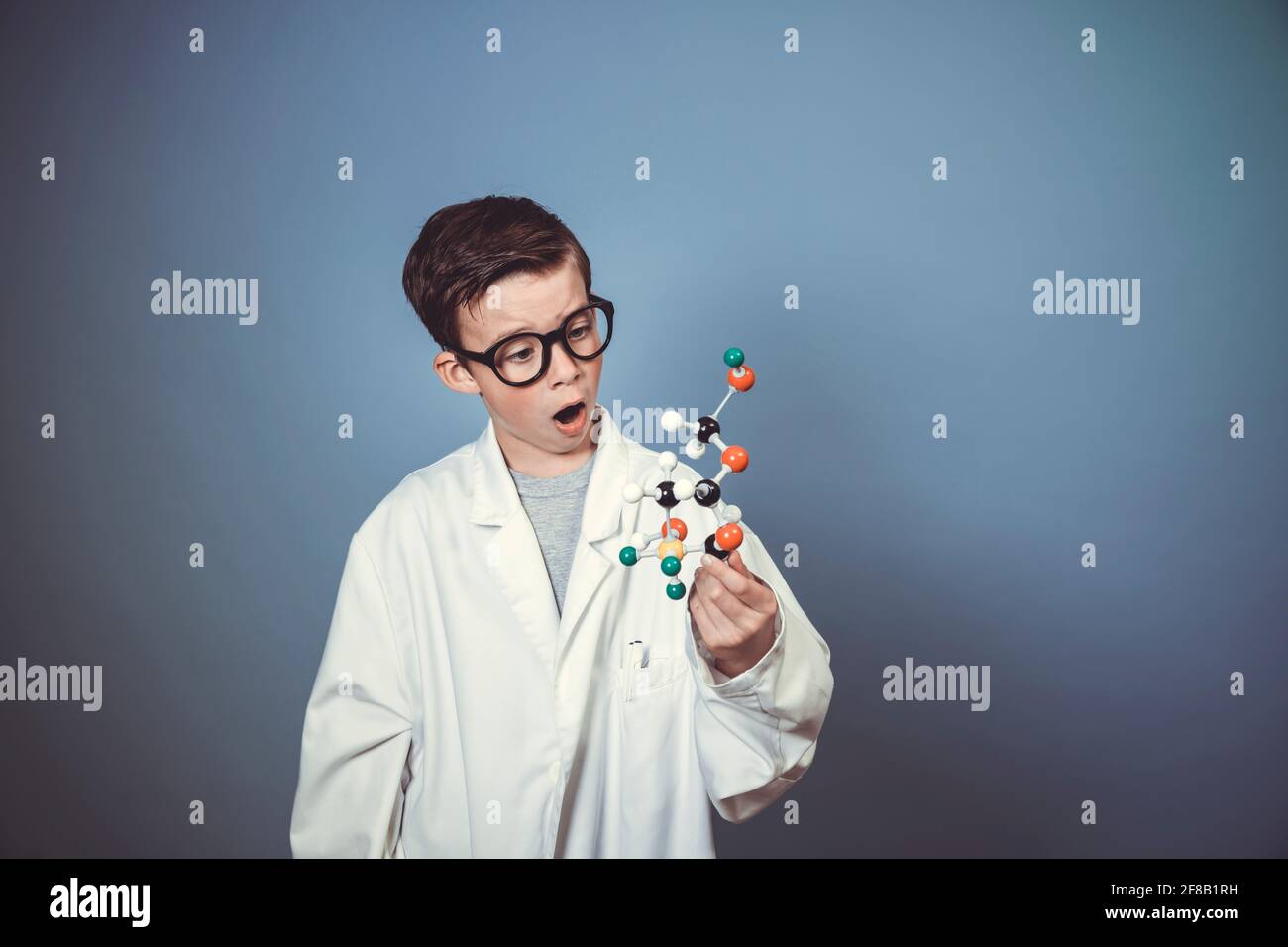cool young boy is dressed as scientist with white lab coat and holding ...