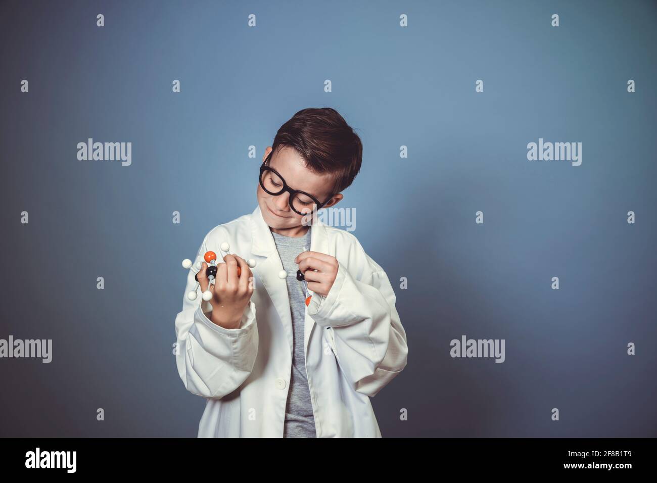 cool young boy is dressed as scientist with white lab coat and holding ...