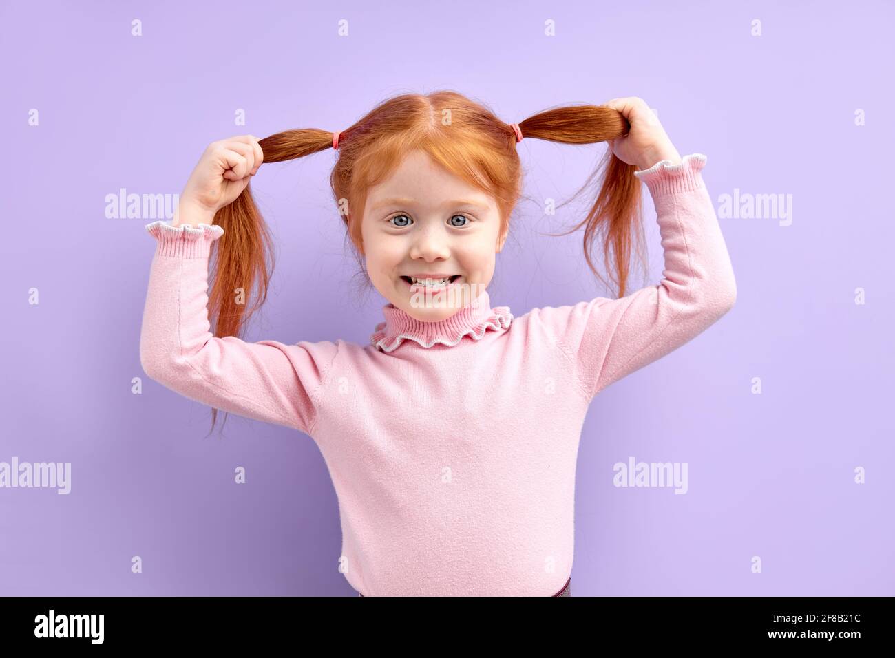 Joyful Kid Girl Have Fun, Holding Two Tails In Hands, Smiling At Camera ...