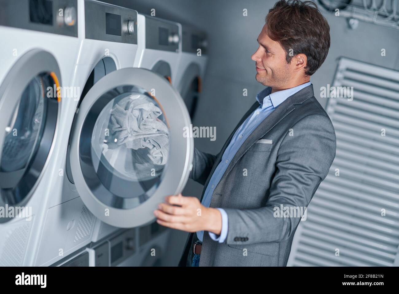 Young businessman in laundry room Stock Photo - Alamy
