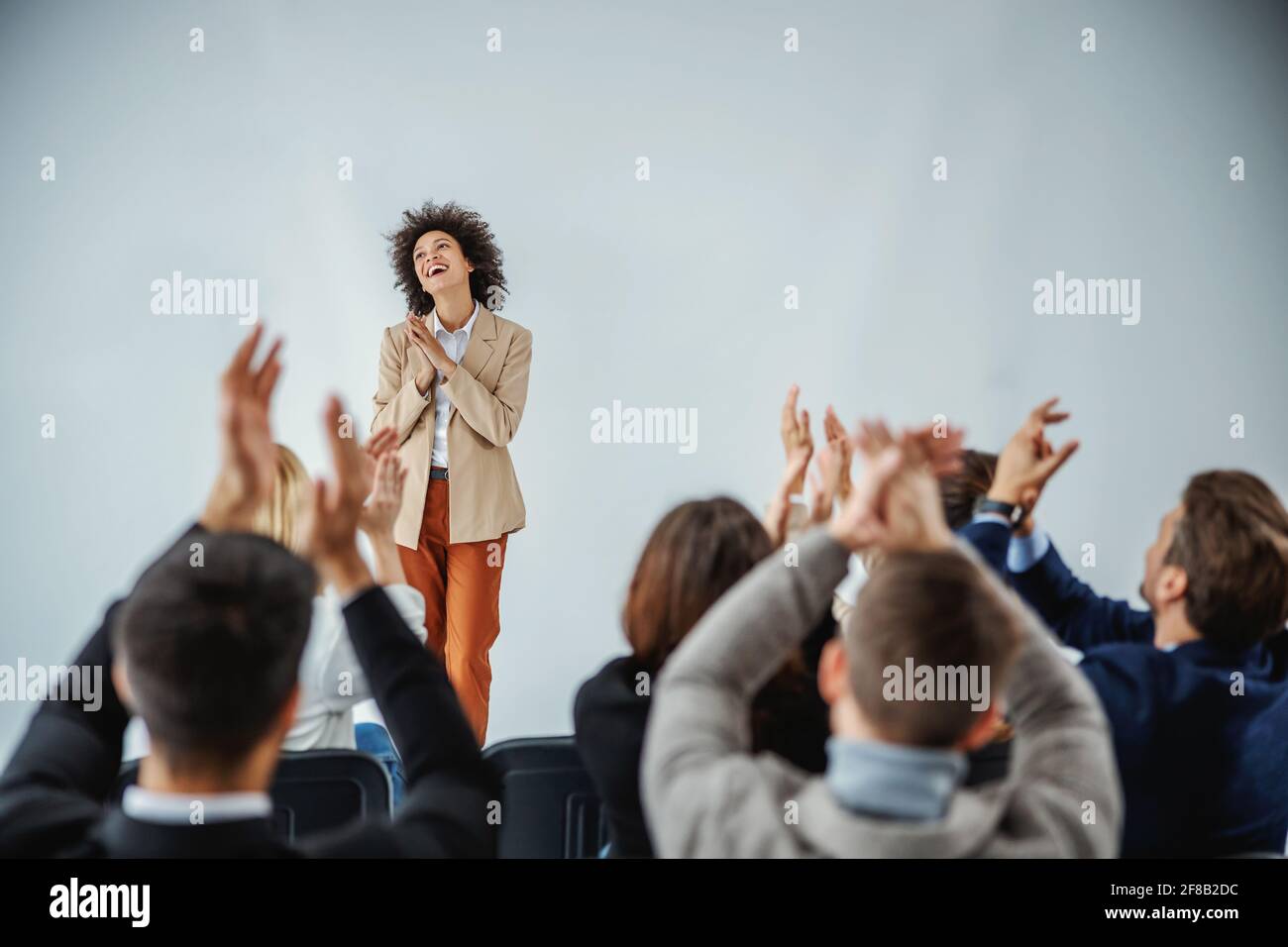 Multicultural group of business people cheering and clapping to a mixed ...