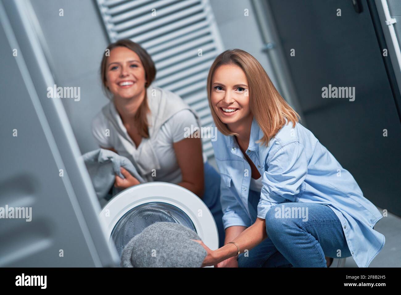 Two students in laundry room Stock Photo - Alamy
