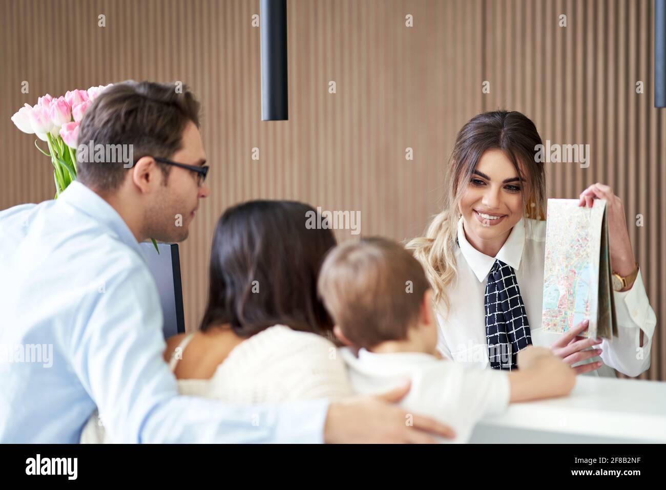 Picture of family checking in hotel Stock Photo - Alamy